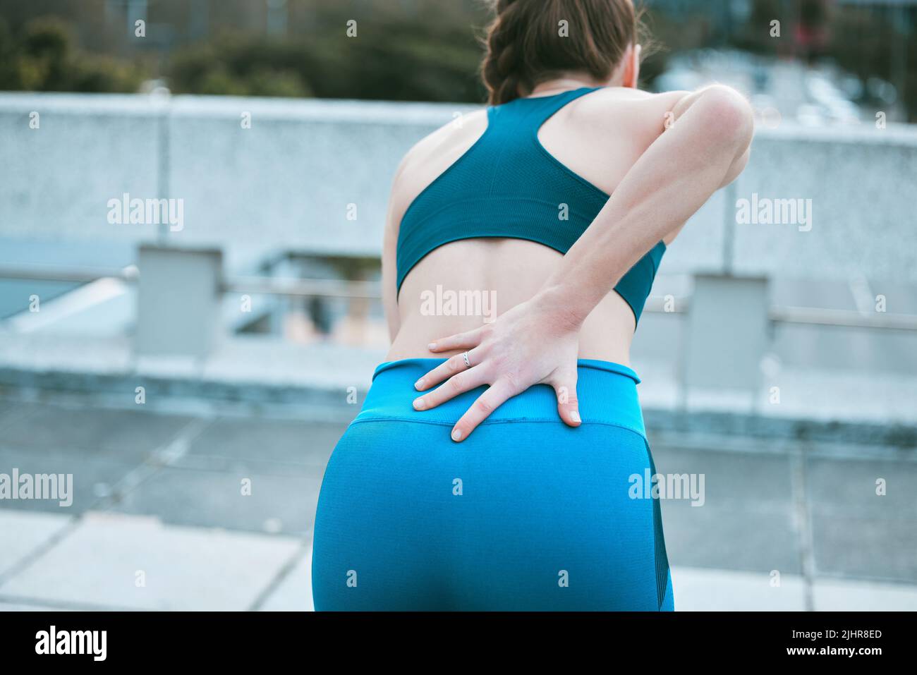 One caucasian woman from behind holding sore lower back while ...