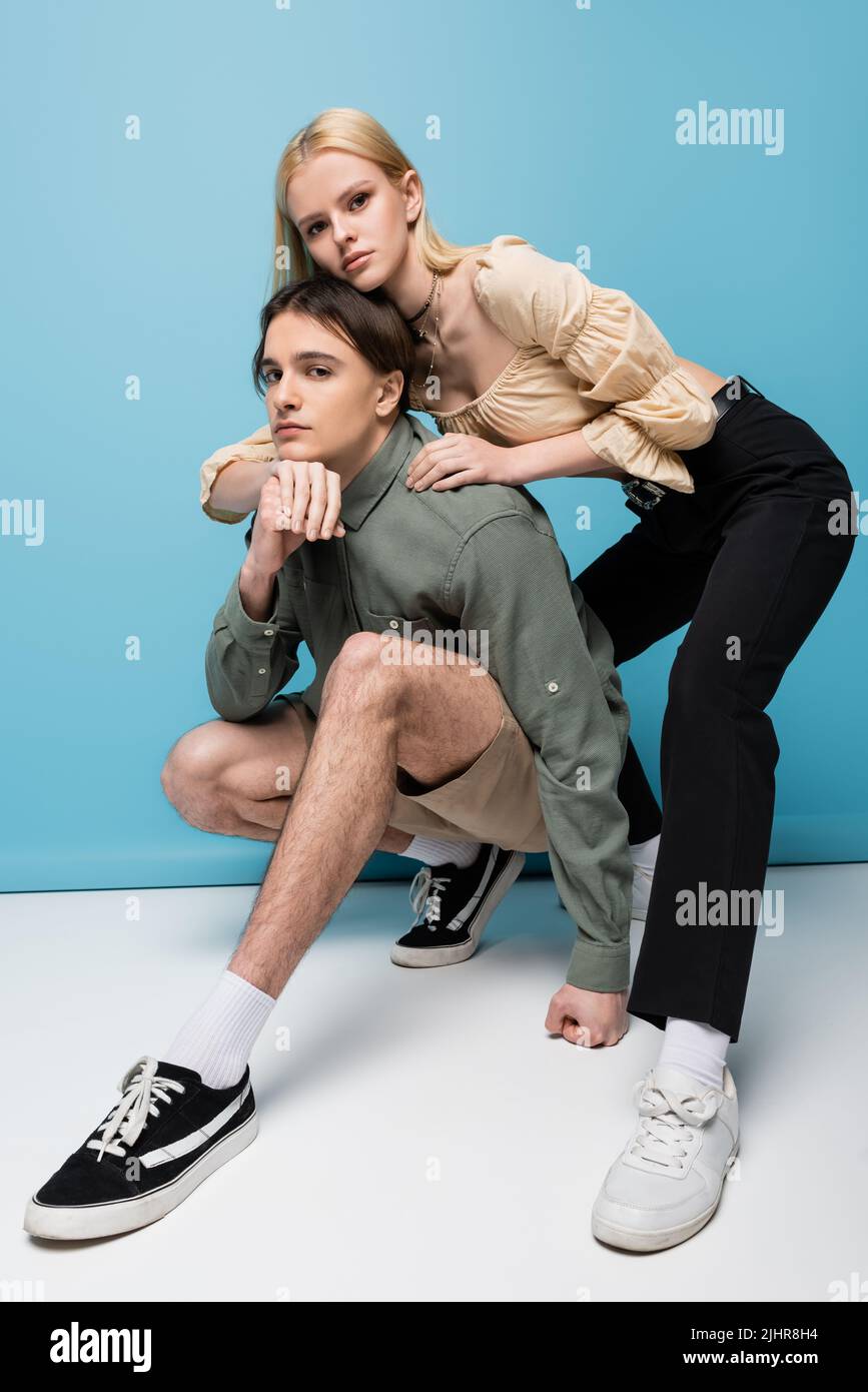 Full length of trendy models posing and looking at camera on blue ...