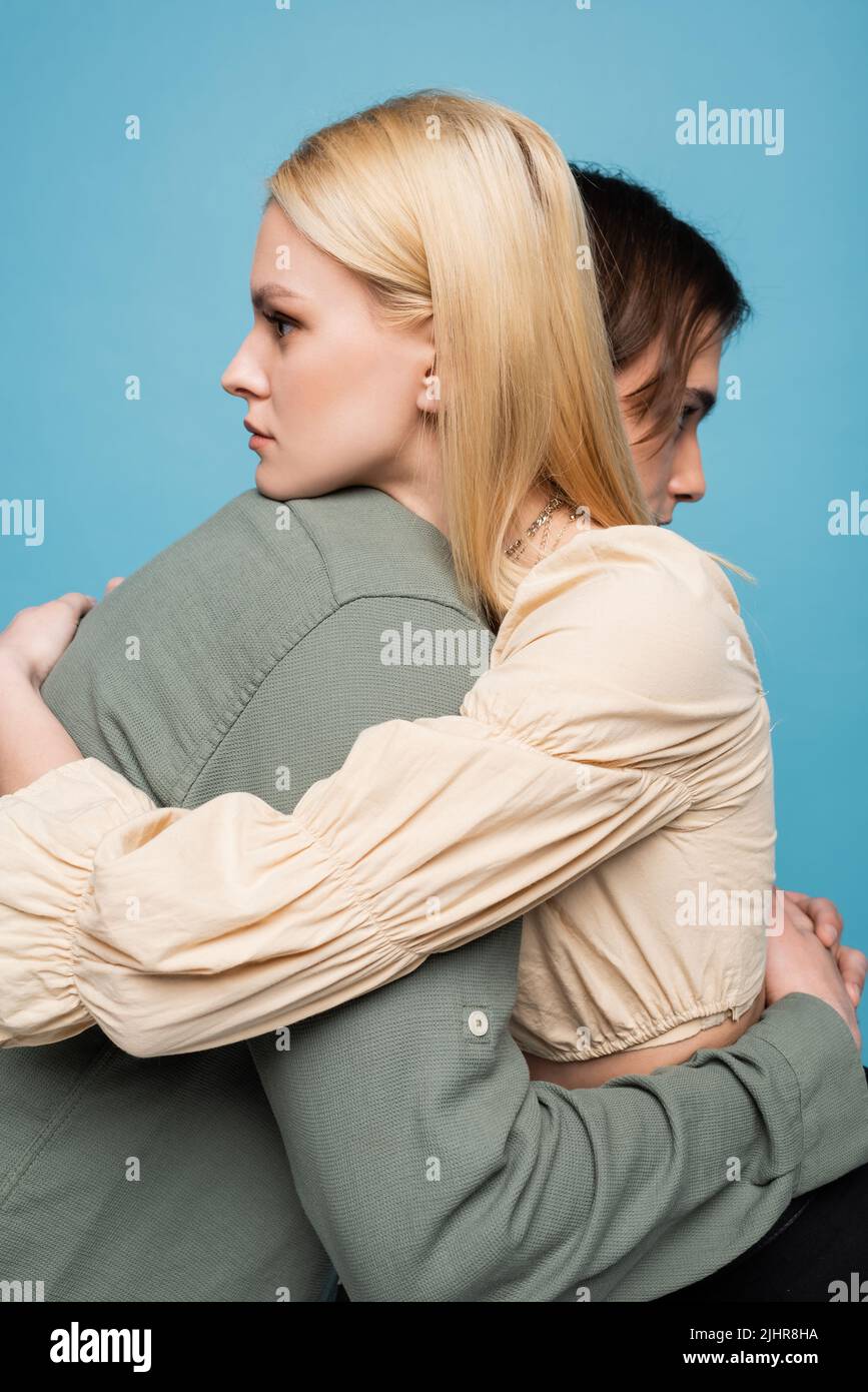 Side view of young couple embracing isolated on blue Stock Photo - Alamy