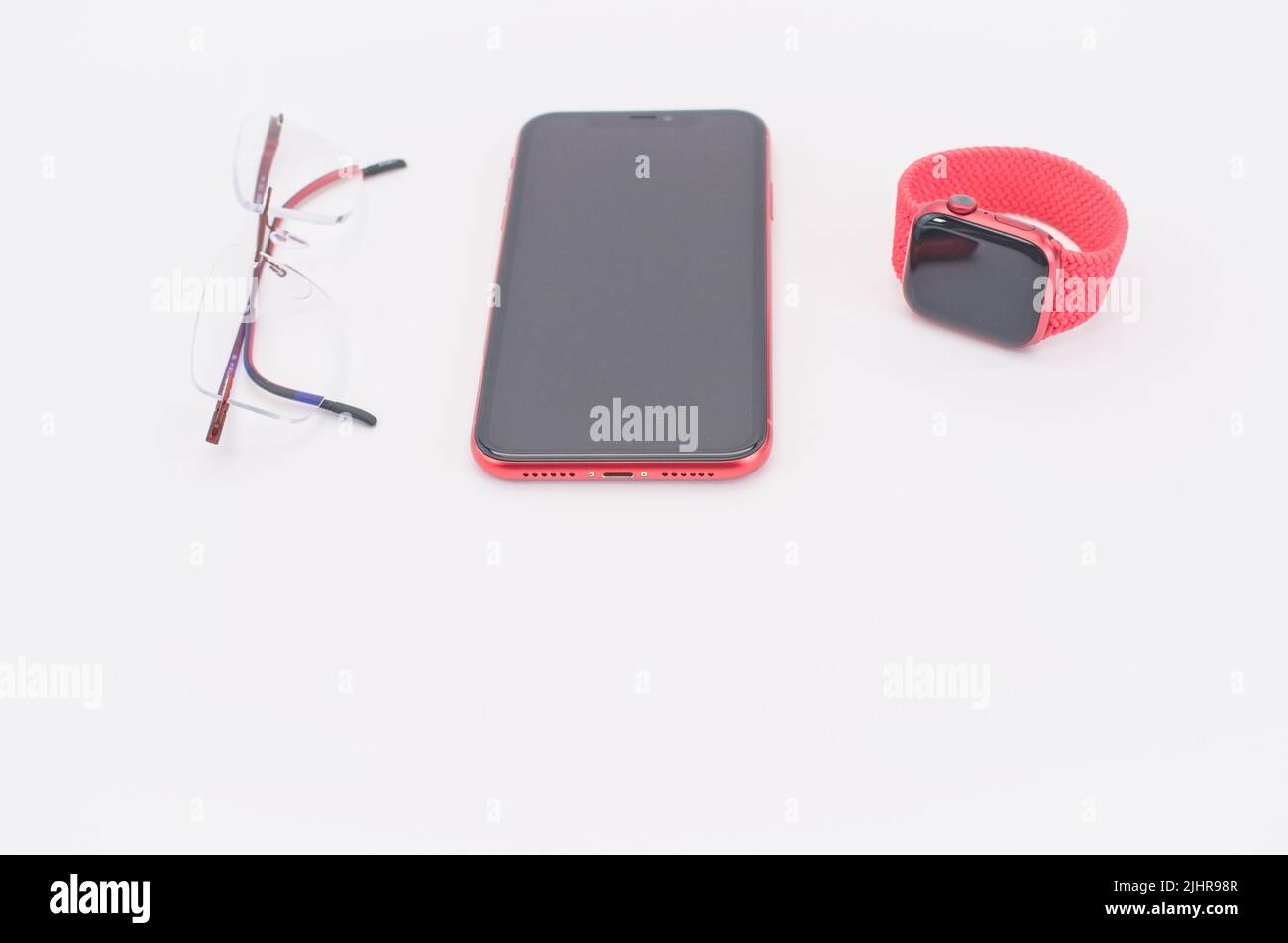Apple iphone and Apple watch Product red on a white desk with space for ...