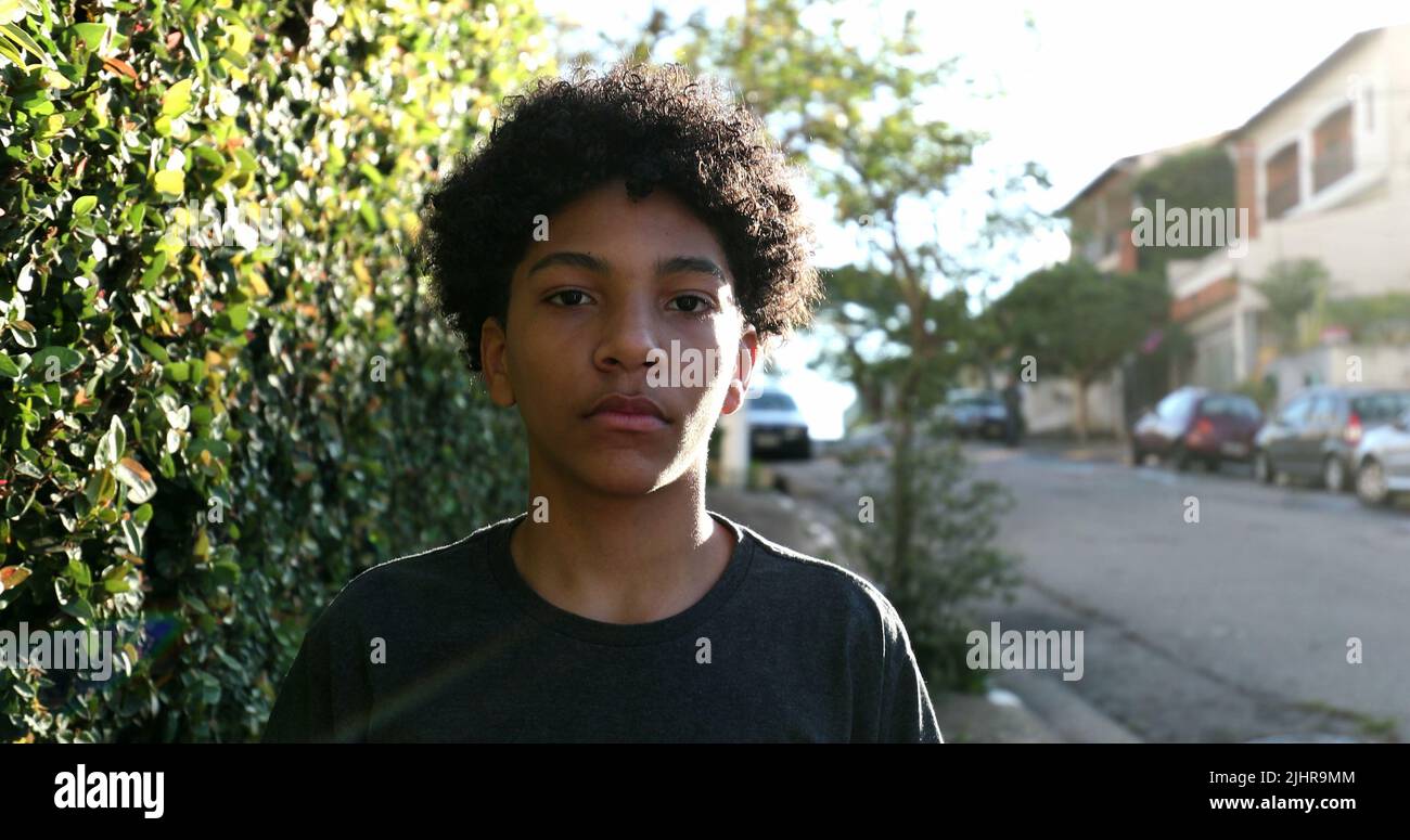 Mixed race kid walking outside in sidewalk street. Young boy walks ...