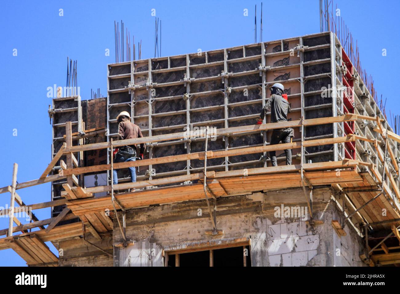 Workers work on the construction of new buildings in the Israeli ...