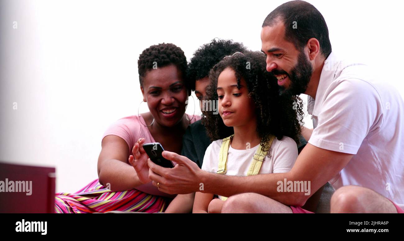 Multi-ethnic family using cellphone. Interracial parents and mixed race ...