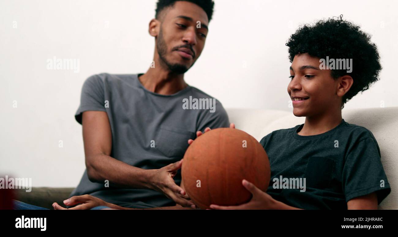 Older brother teaching younger sibling to spin basketball with finger ...