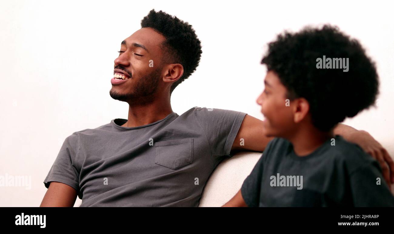 Older brother chatting with younger sibling. Candid mixed race two ...