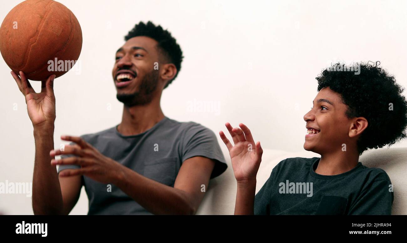 Older brother teaching younger sibling to spin basketball with finger ...
