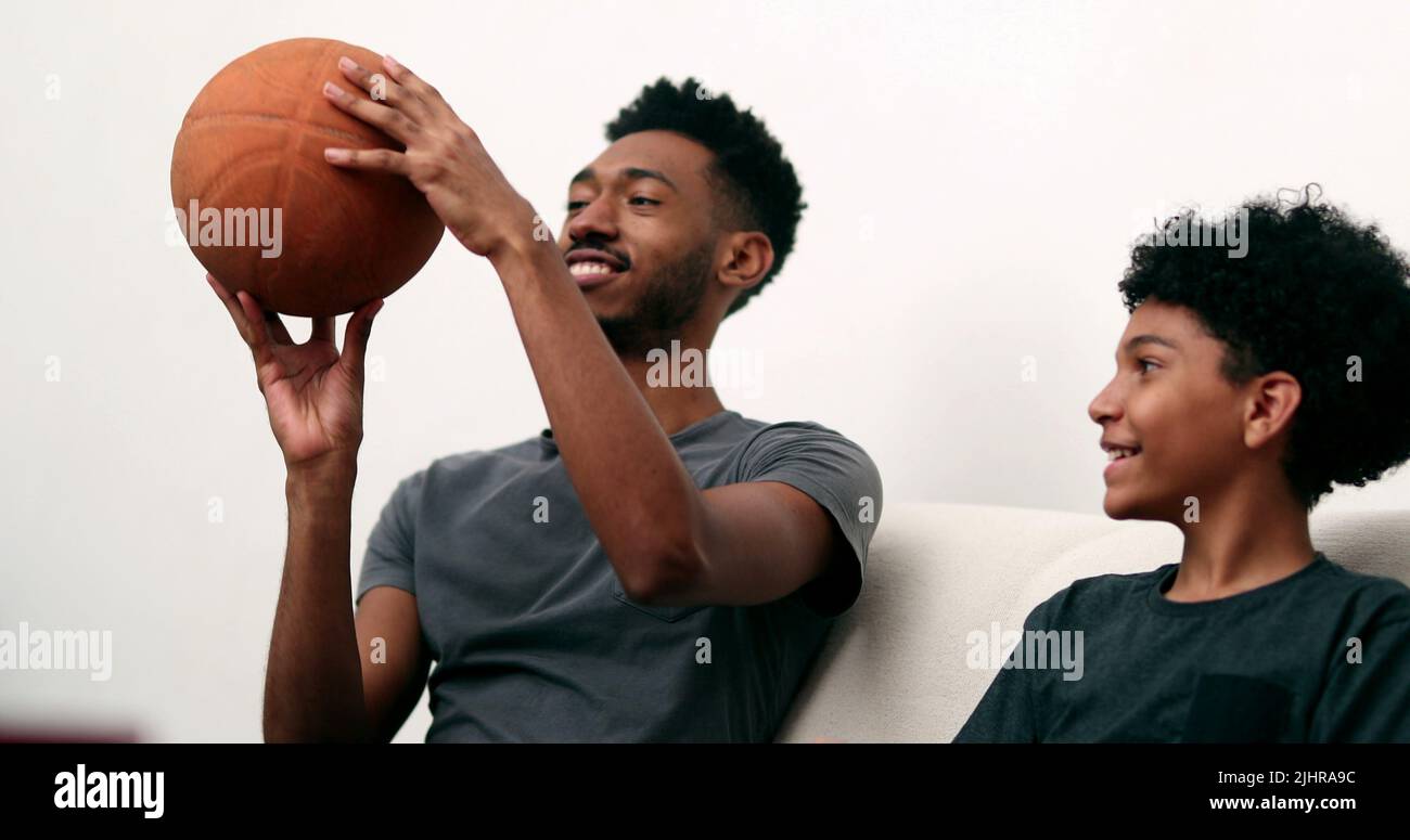 Older brother teaching younger sibling to spin basketball with finger ...