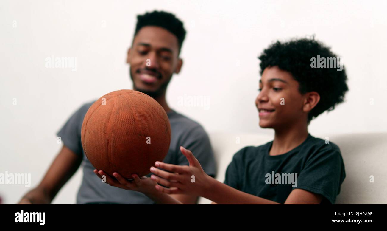 Older brother teaching younger sibling to spin basketball with finger ...