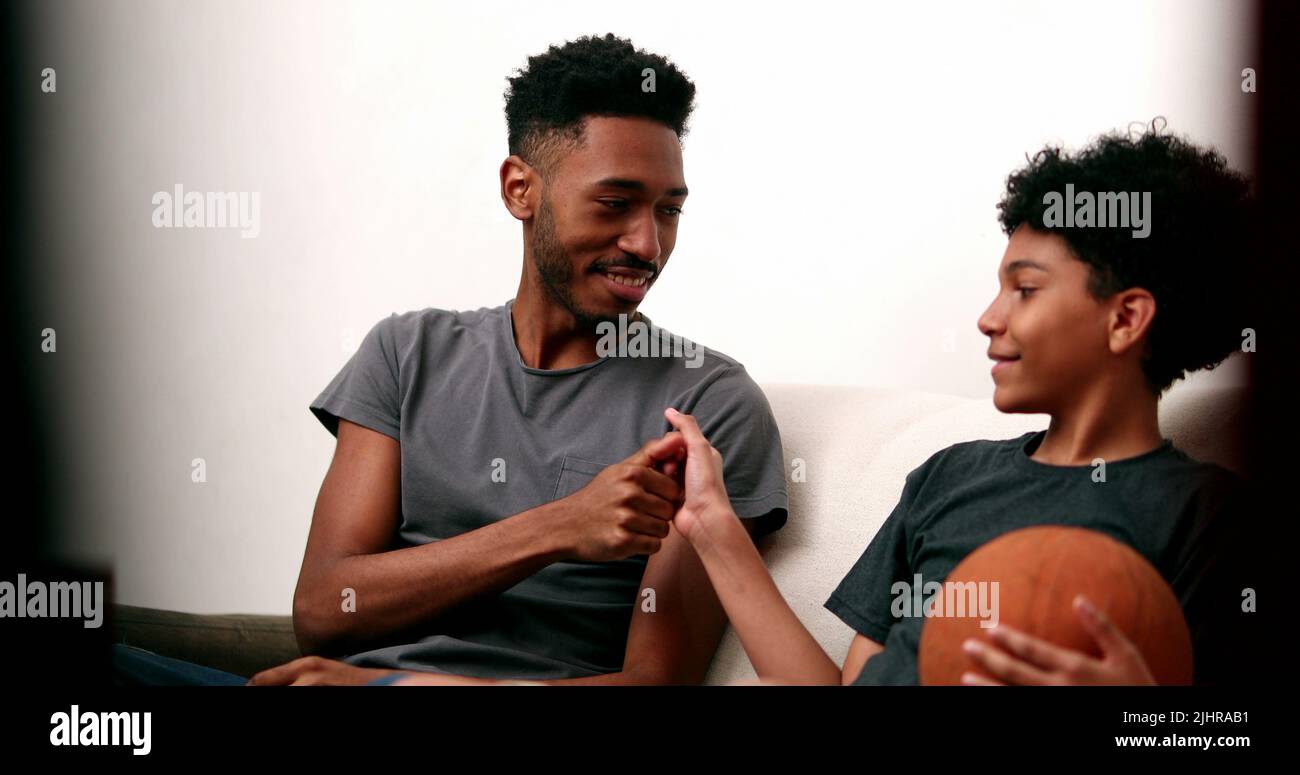Older brother teaching younger sibling to spin basketball with finger ...