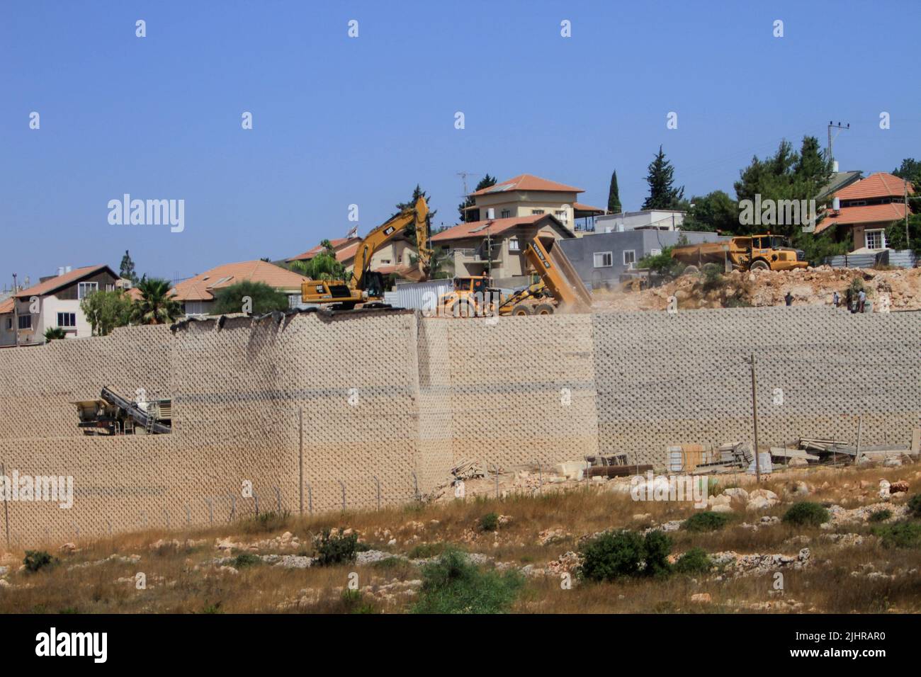 Bulldozers work on the construction of new buildings in the Israeli ...