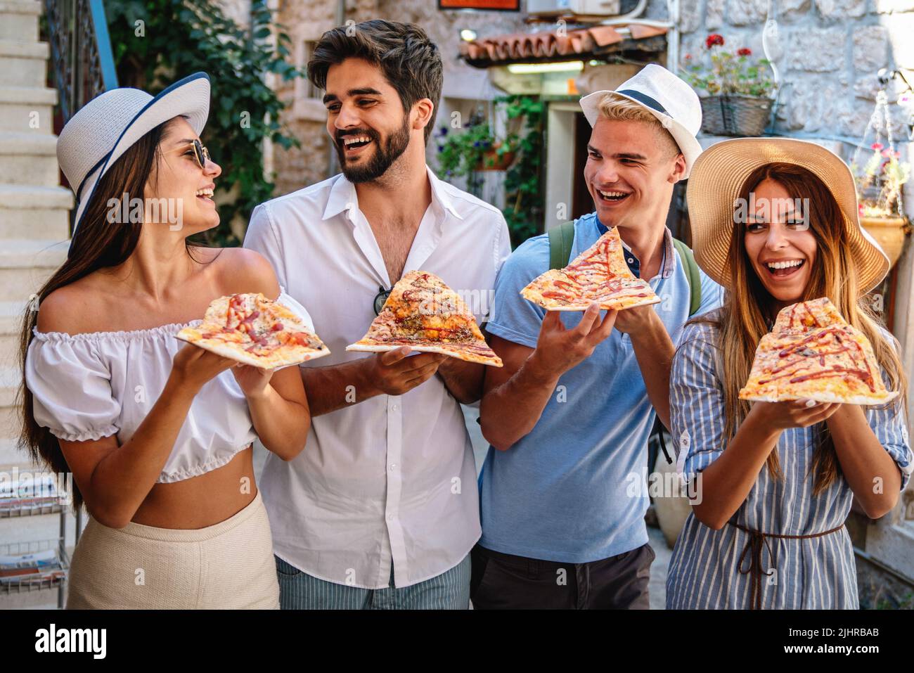 Happy traveling tourists friends having fun, eating pizza on summer ...