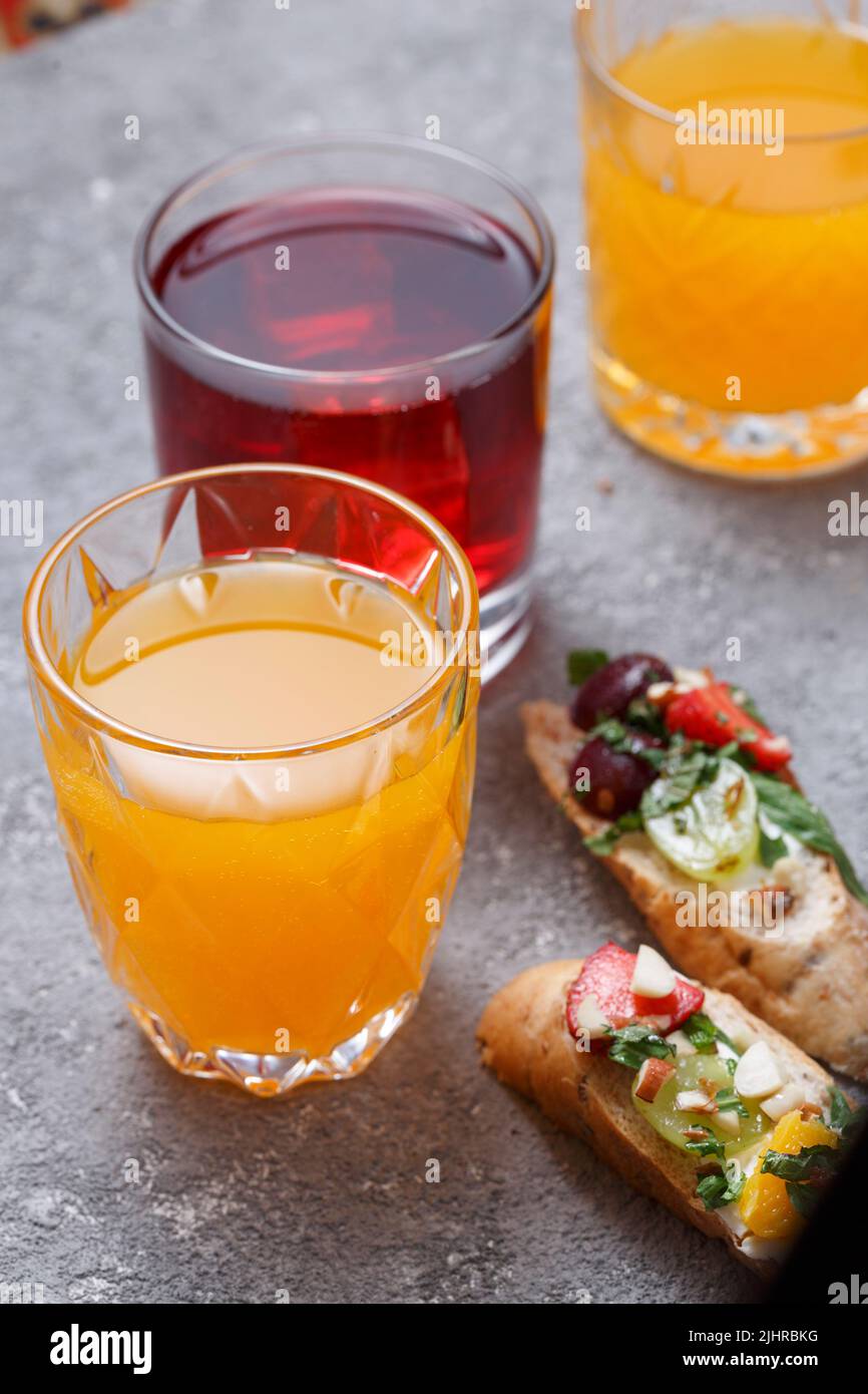 Summer drinks and toasts with fruits on a gray table. Healthy food, dietary snack, vegetarian ...