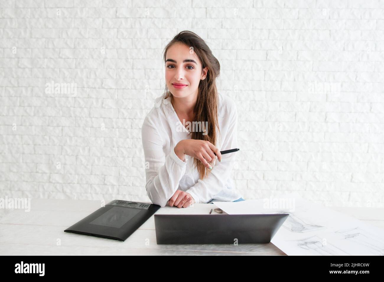 Female designer looking at camera on workplace Stock Photo - Alamy