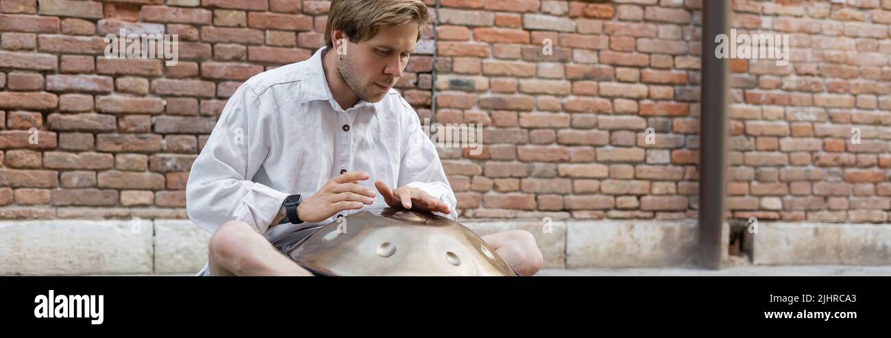 Street musician playing handpan in Venice, banner Stock Photo - Alamy