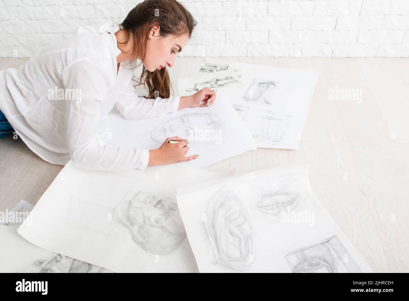 Successful woman artist drawing in workshop Stock Photo - Alamy