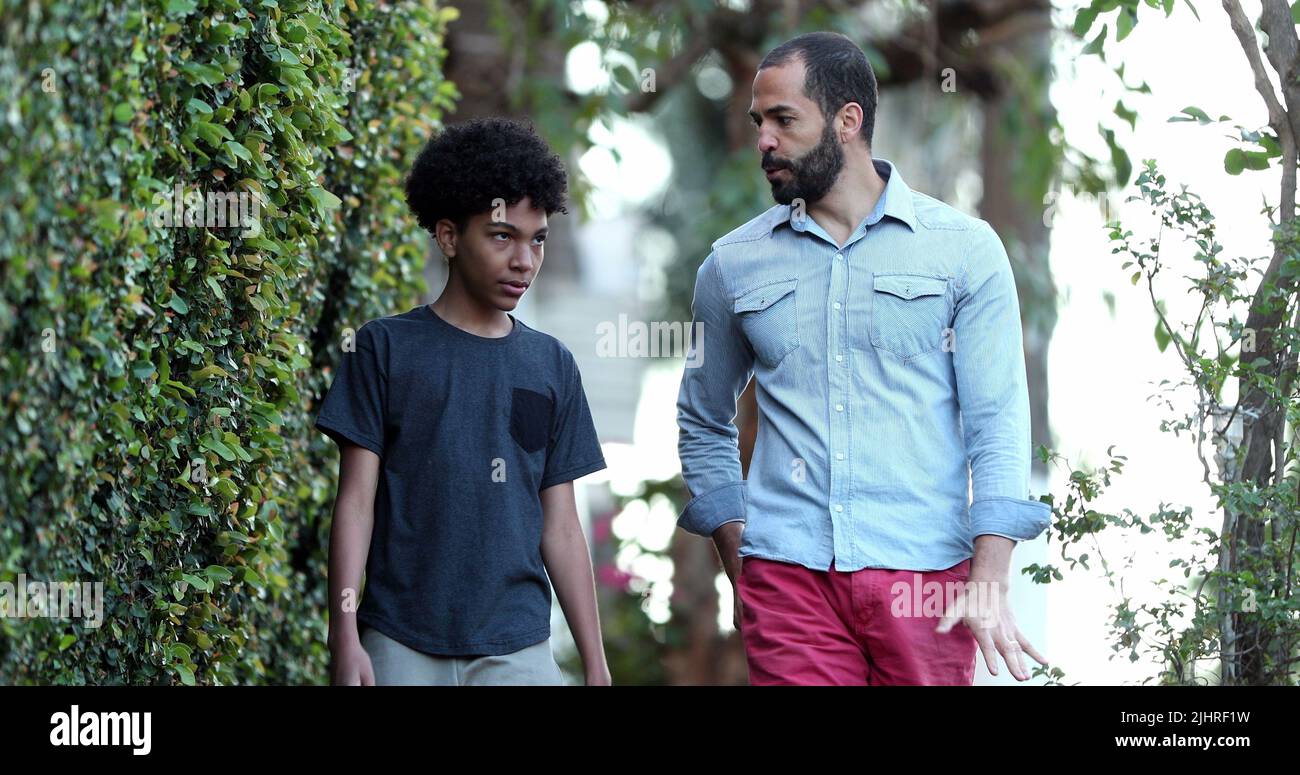 Parent and child walking together. Father giving advice to son, dad and ...