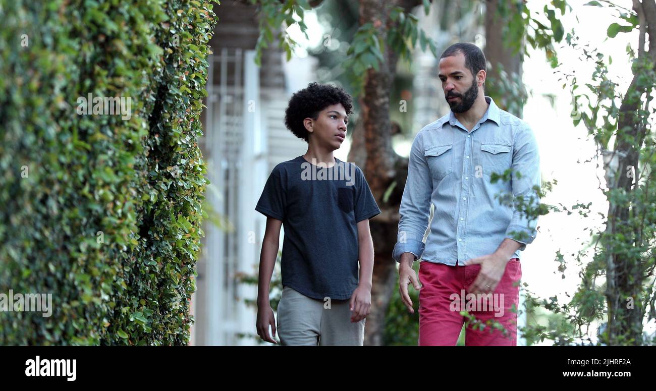 Parent and child walking together. Father giving advice to son, dad and ...