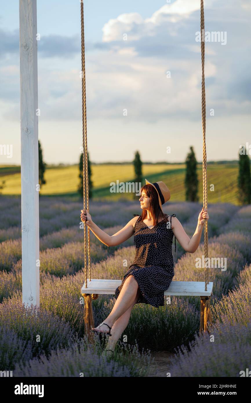 Pretty young woman on lavender field swinging Stock Photo - Alamy