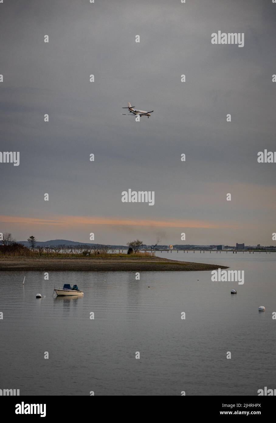 The private jet flies over the sea at sunset Stock Photo - Alamy