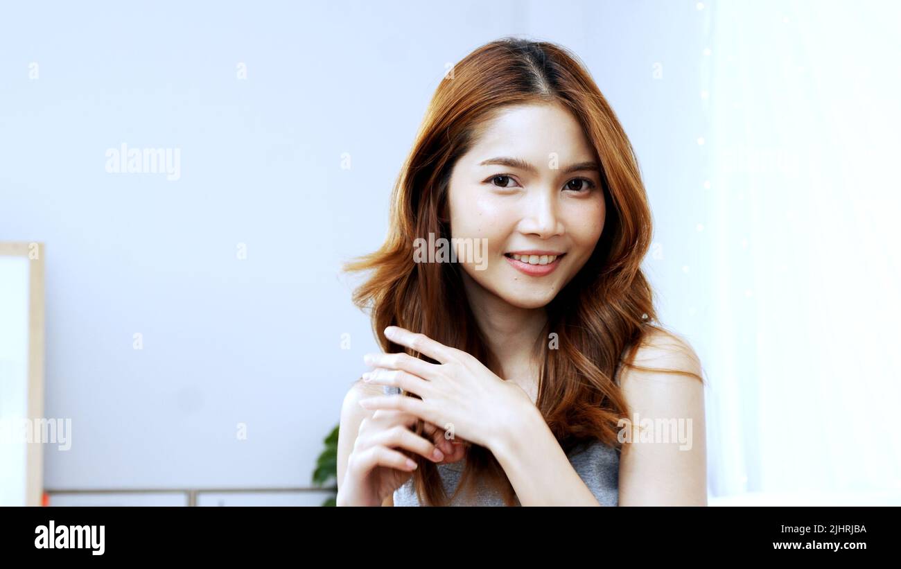 A beautiful Southeast Asian female posing for a photo in a bedroom ...