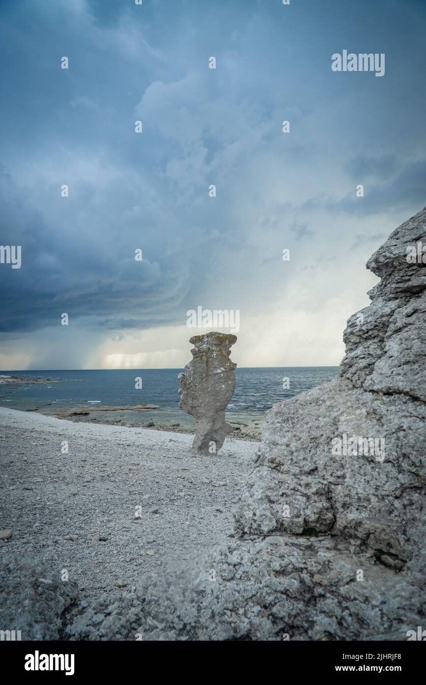 A vertical shot of the stones by the beach with an amazing sky ...
