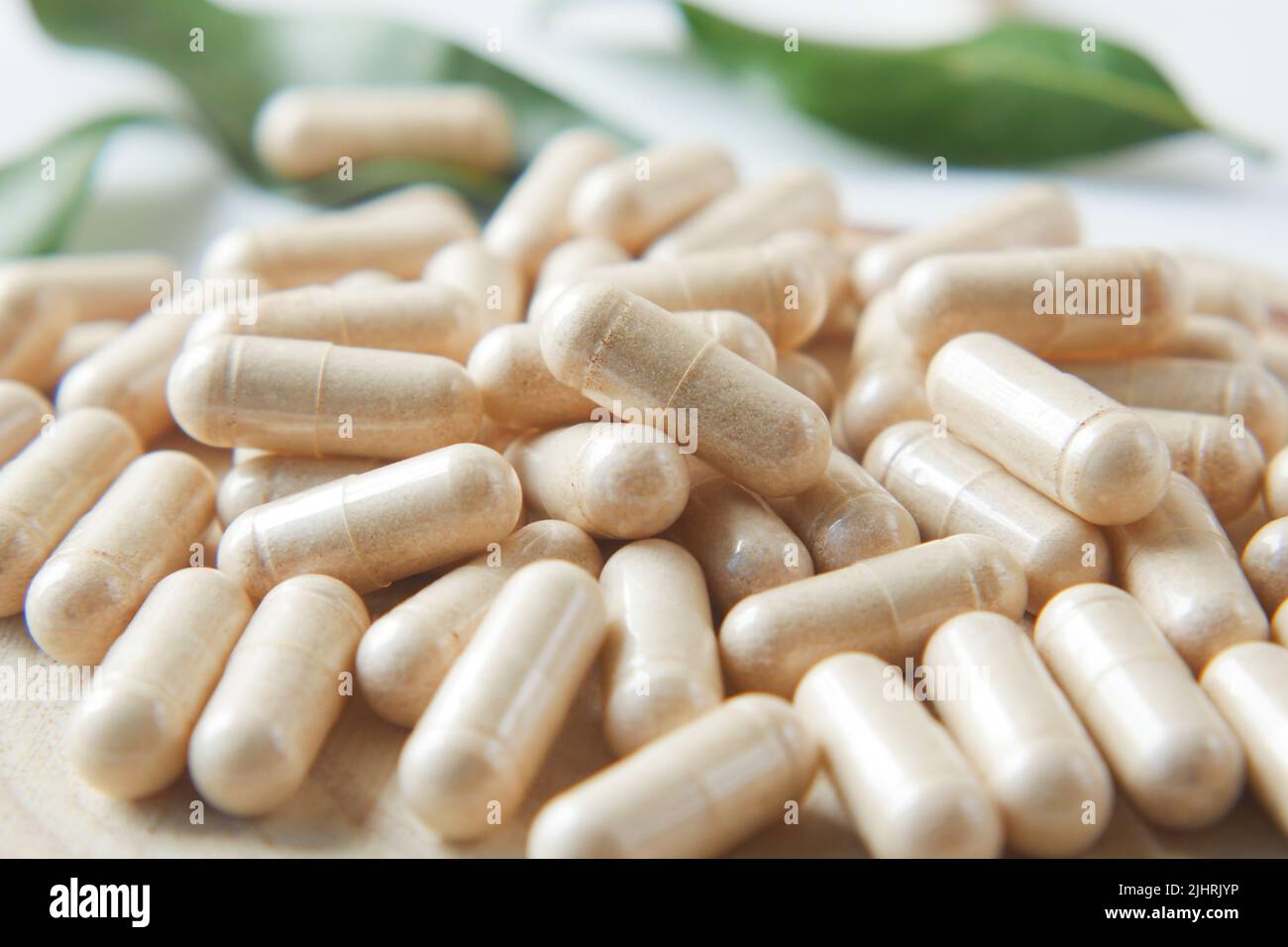 top view of herbal medicine capsule dropping on white Stock Photo - Alamy