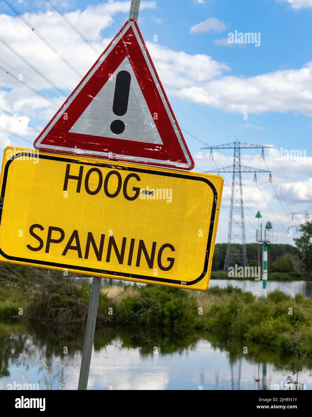A sign of high voltage warning With the river Maas on the background ...