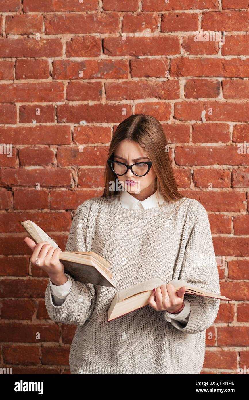 Very smart girl reading two books at same time Stock Photo - Alamy