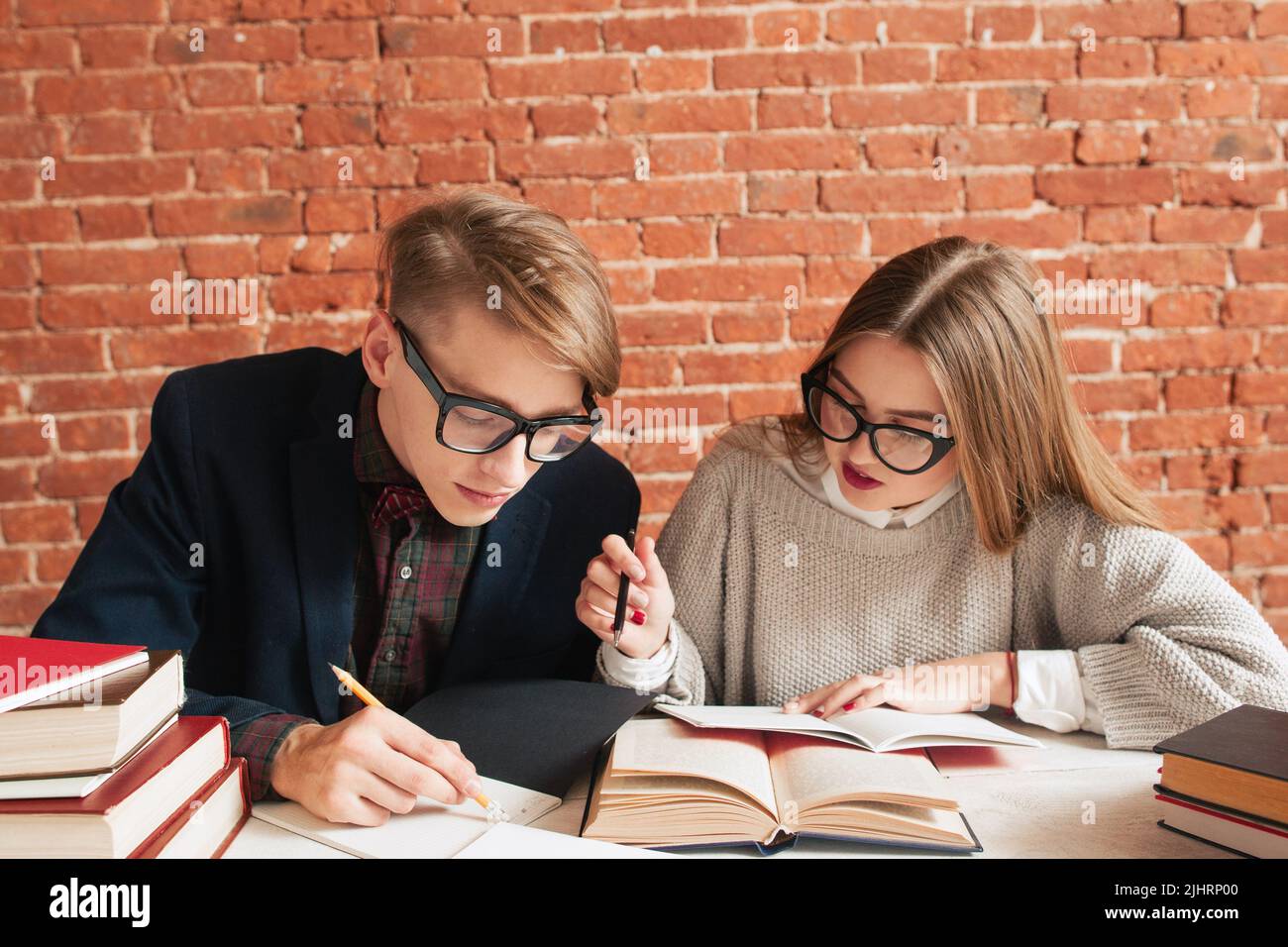 Students man and woman studying in library Stock Photo - Alamy