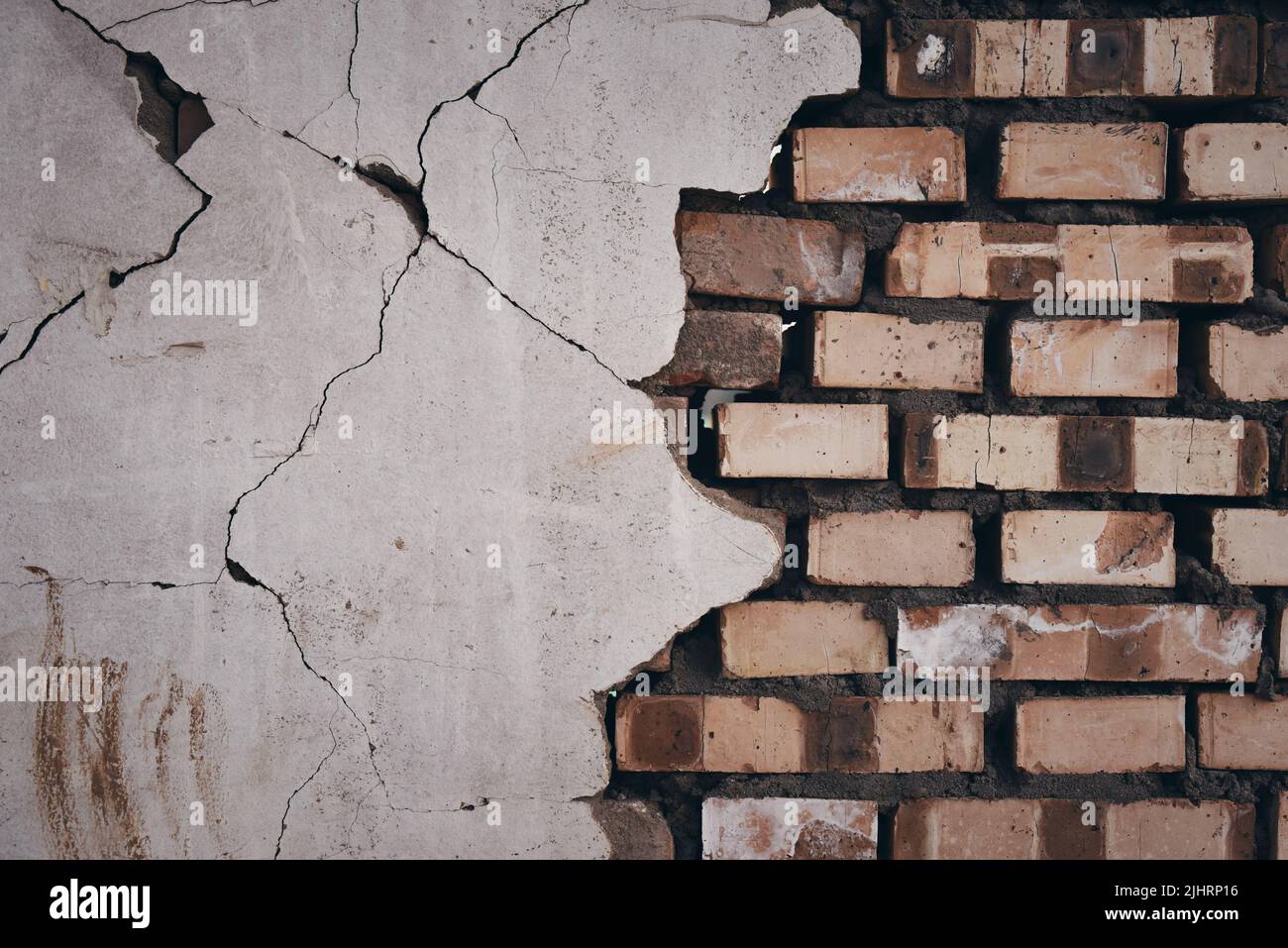 A wall with a half of bricks and other half of cracked cement Stock ...