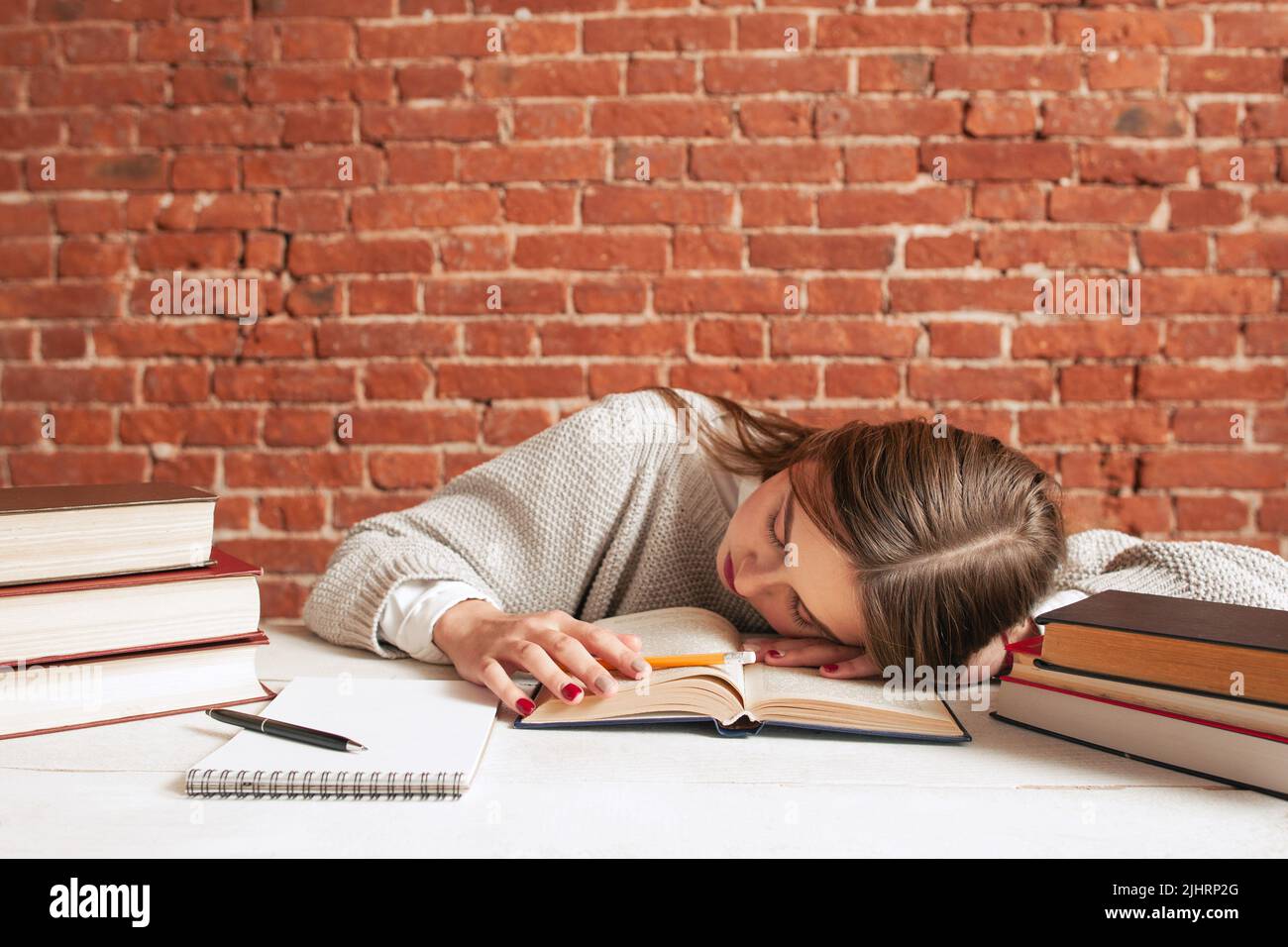 Tired student sleeping at library, free space Stock Photo - Alamy