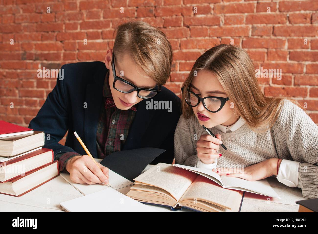 Pair of students carefully reading textbook Stock Photo - Alamy