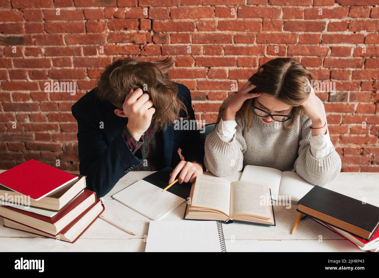 Pair of tired students preparing for exams Stock Photo - Alamy