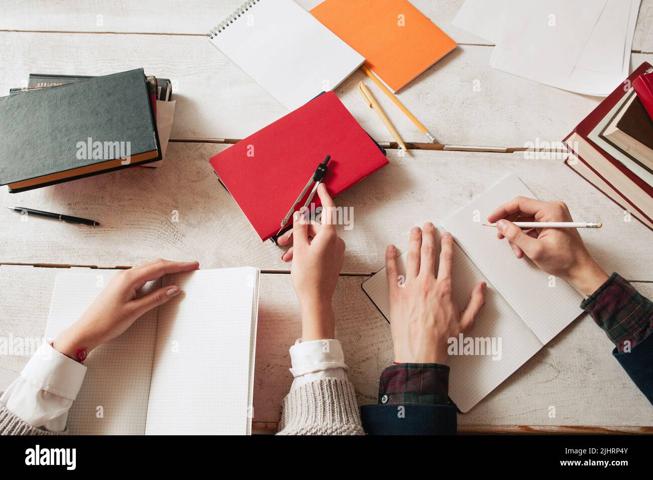 Hands writing on desk with supplies, student pov Stock Photo - Alamy