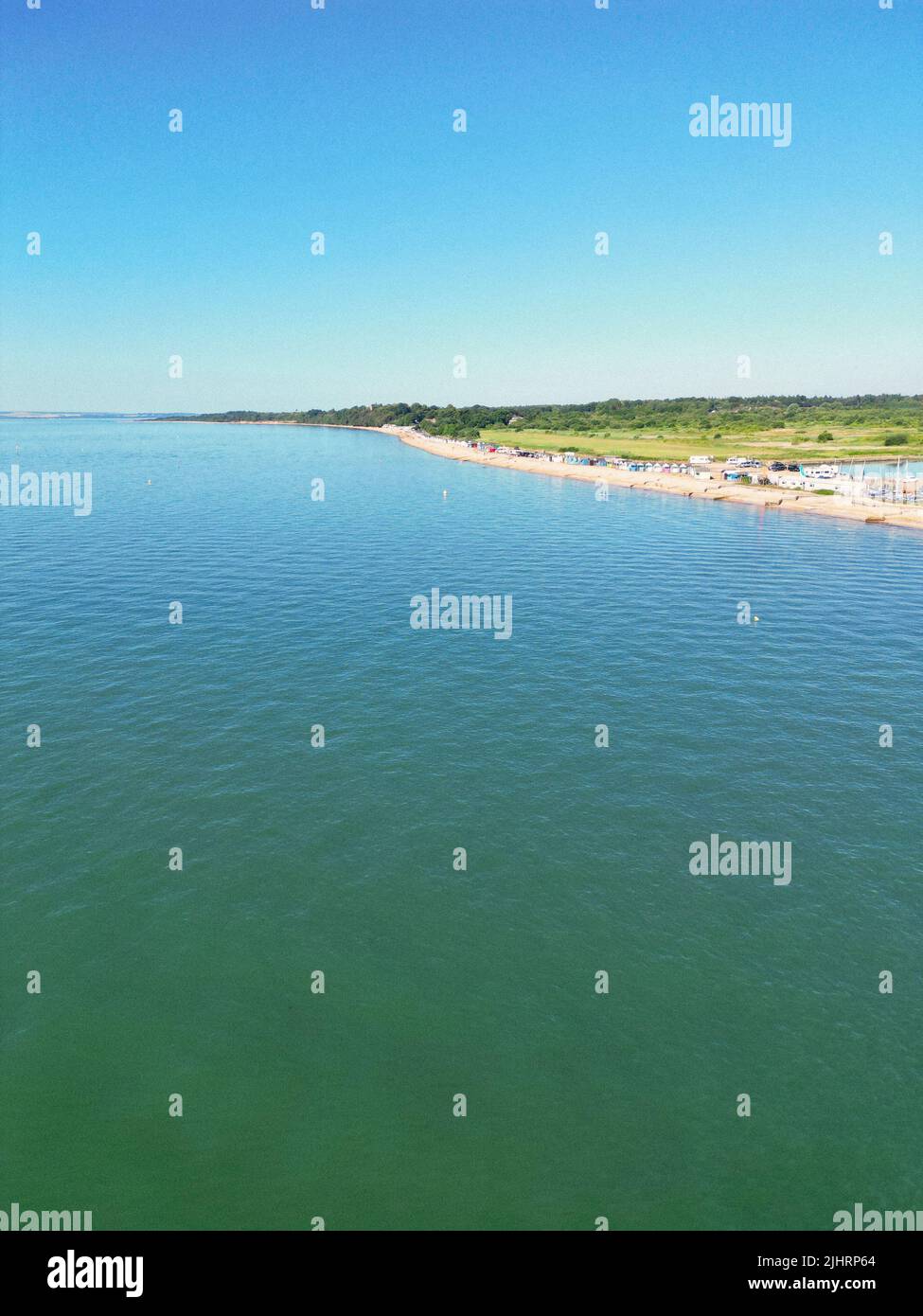 An aerial view of the seascape and the beach with a green space on the ...