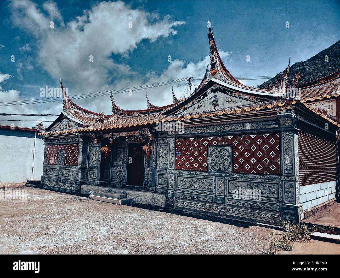 A traditional Asian rural house with colorful ornaments against blue ...