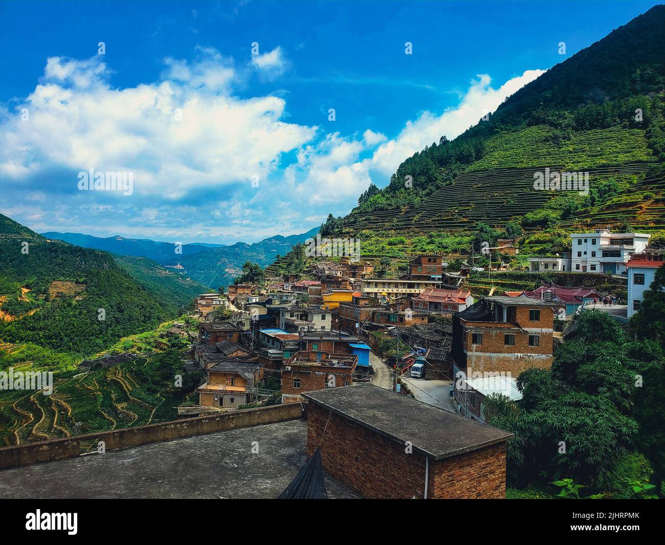 An aerial view of hillside rural houses surrounded by lush greenery ...