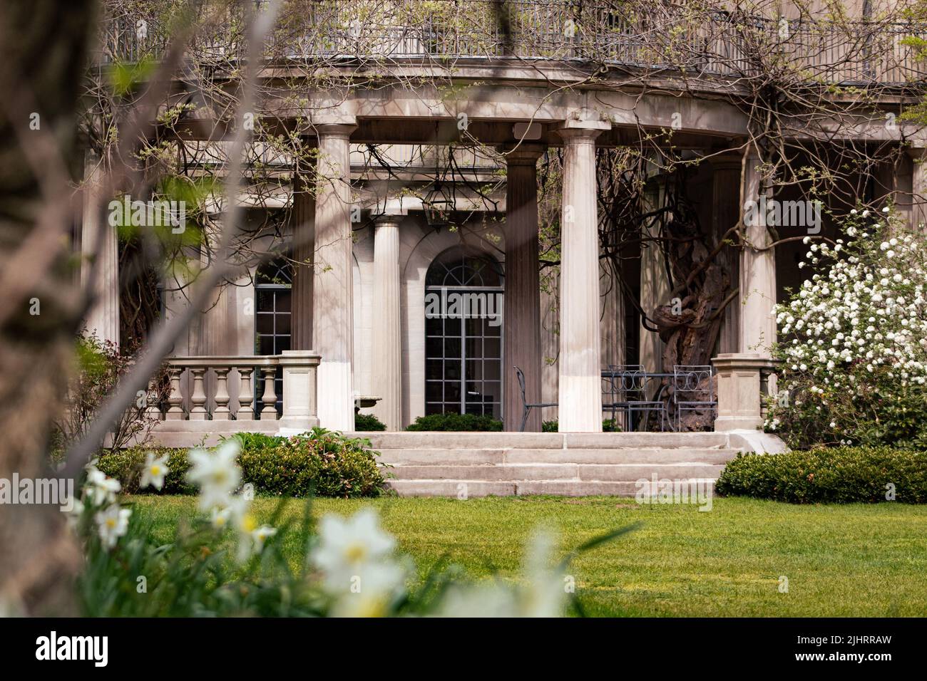 A Victorian building with large pillars surrounded by plants Stock ...