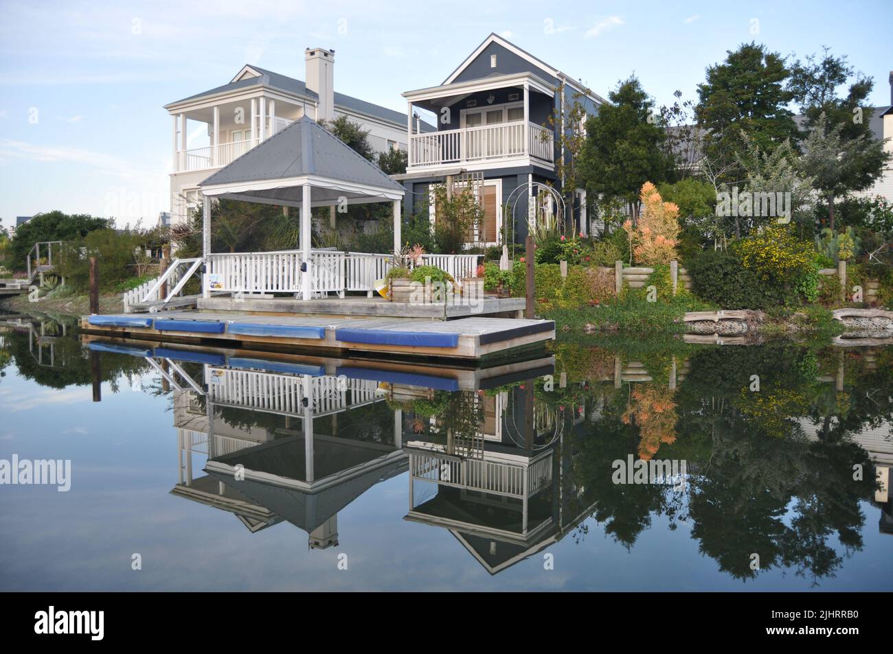 Waterfront house in a marina at dawn or dusk with clear skies and ...