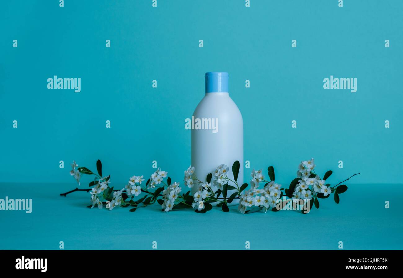 A bottle for cosmetic products without a label with a flower branch at ...