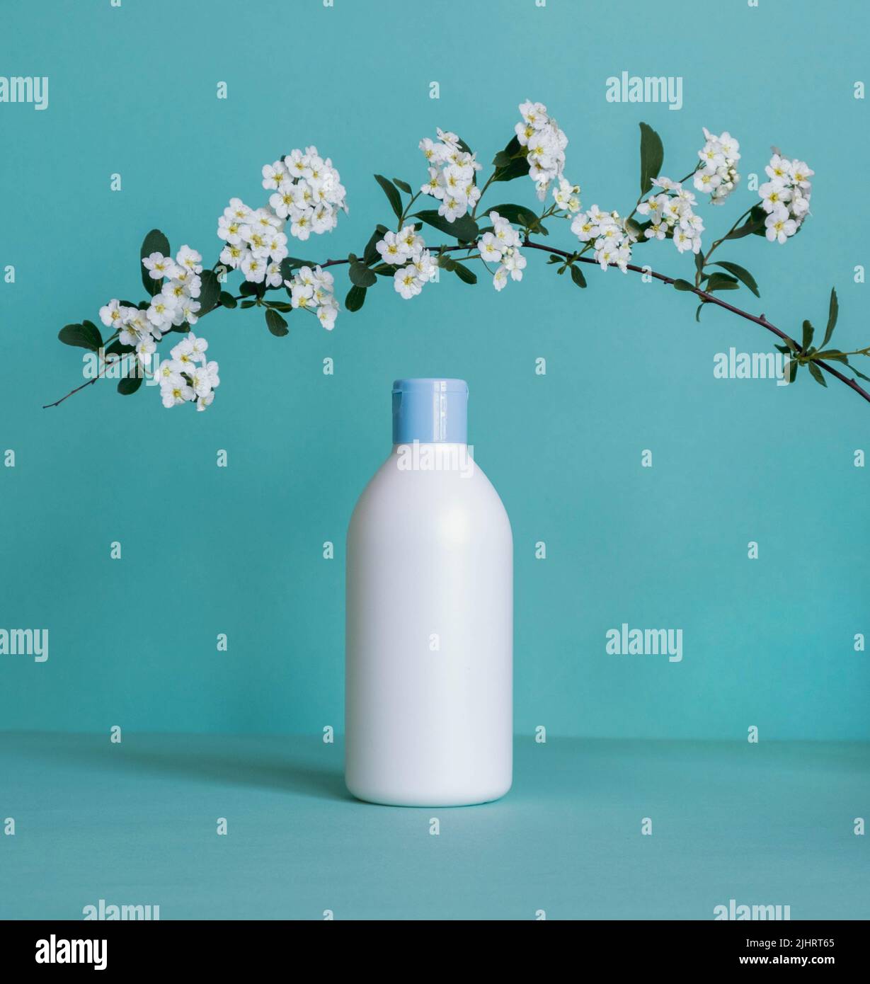 Bottle for cosmetic products without a label with a flower branch ...