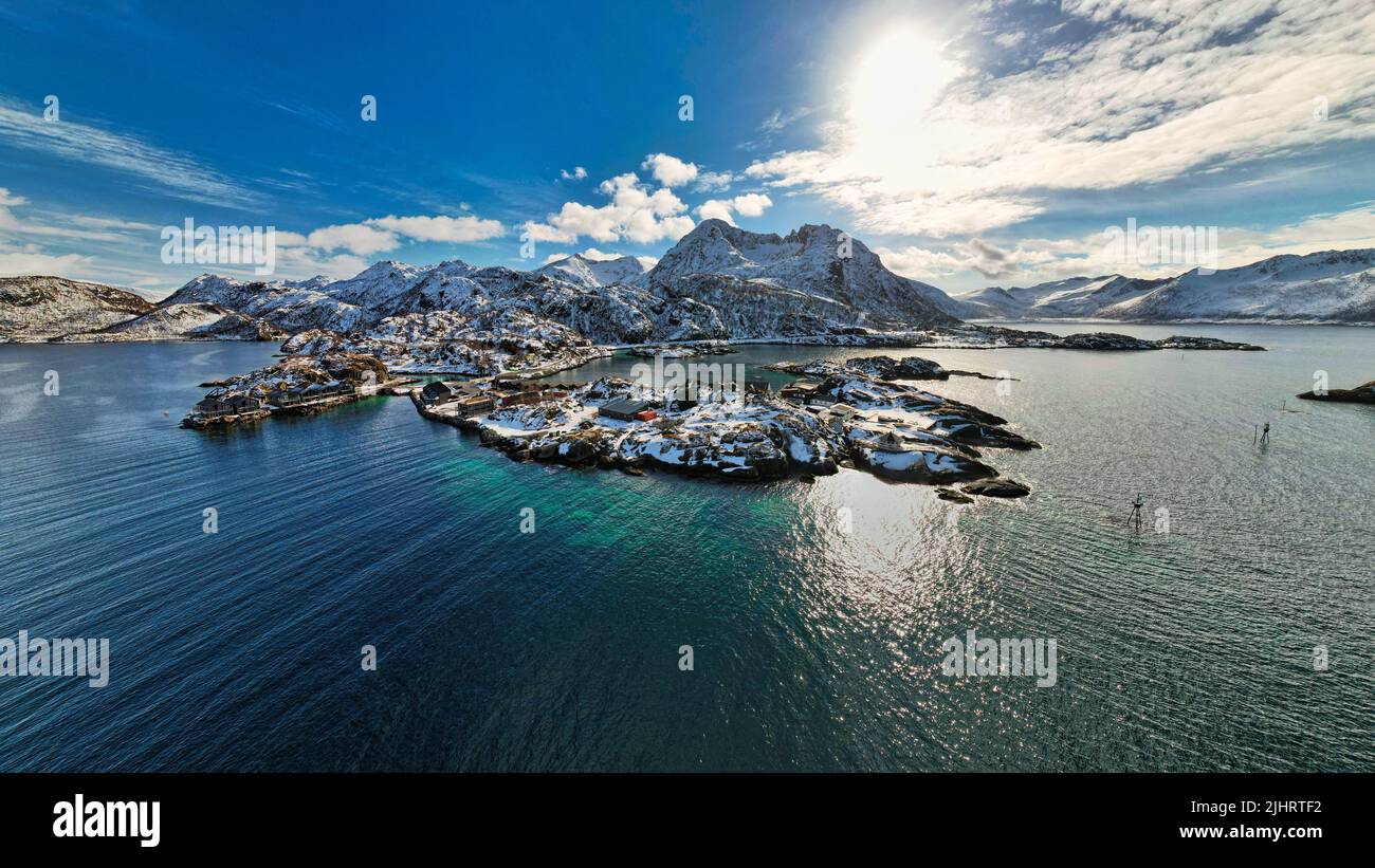 An aerial view of Hamn in Senja island surrounded by snowy mountains in ...