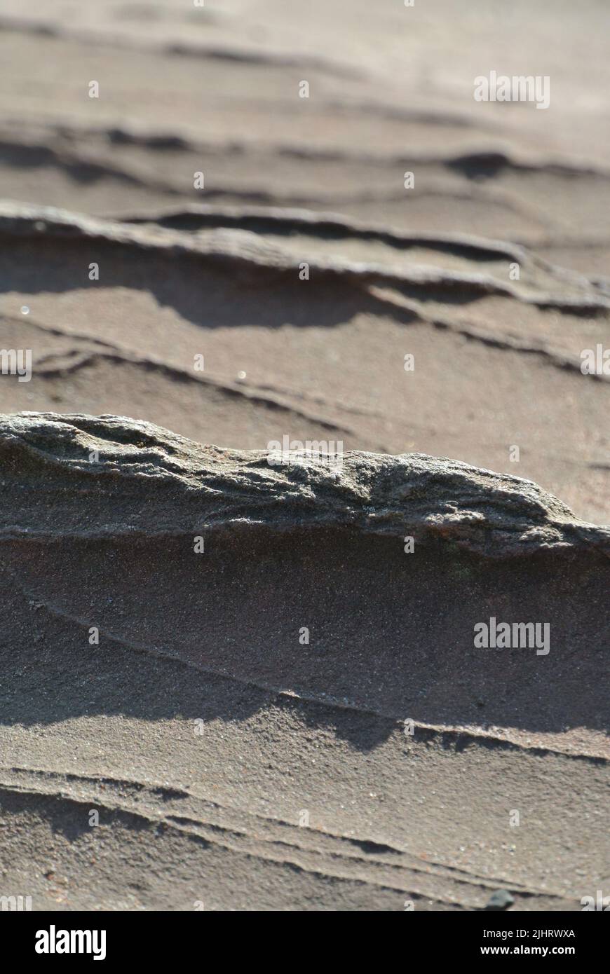 A vertical shot of sediment strata shown in the surface of sandstone ...