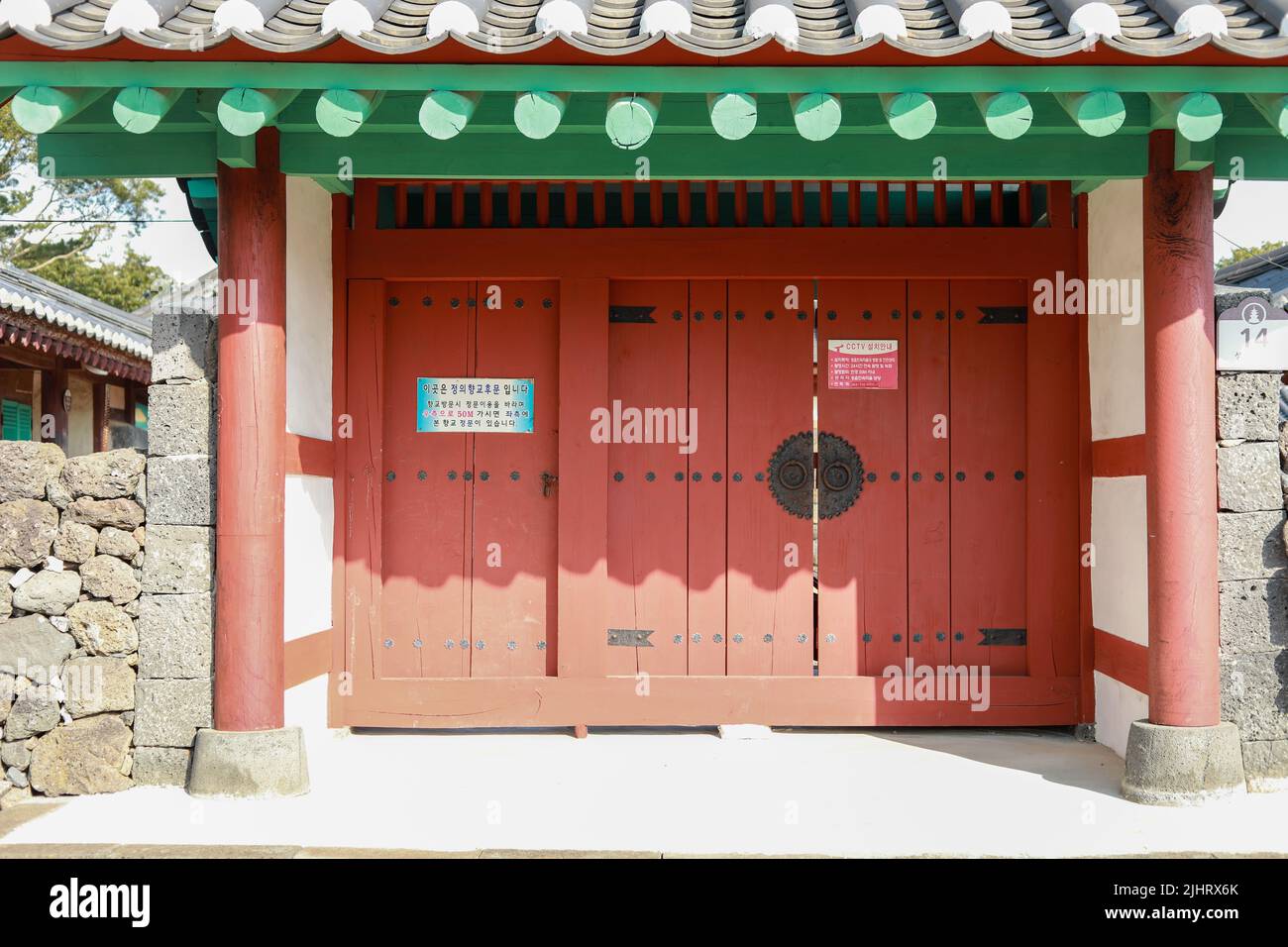 An Asian styled building with a red gate and columns Stock Photo - Alamy