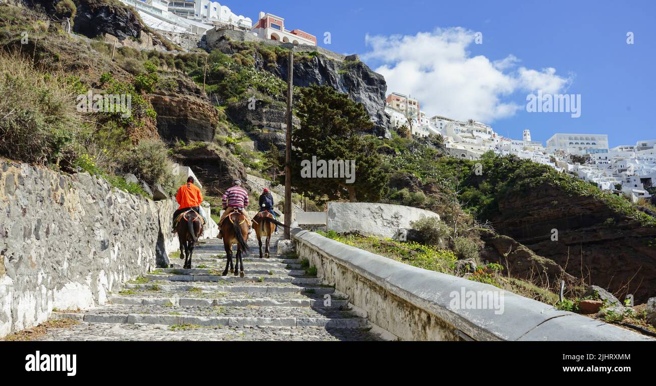 A group of people riding horses in the beautiful Santorini, Greece ...
