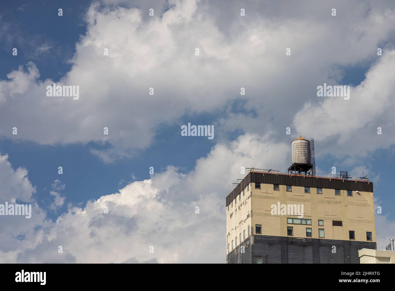 A water tower above commercial building against cloudy blue skies Stock ...