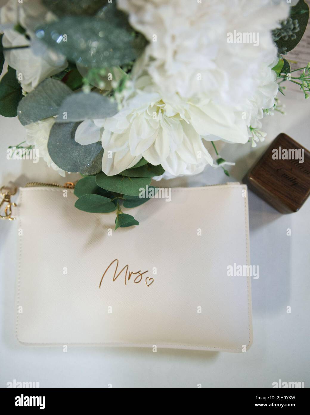 A vertical shot of a Mrs envelope and a ring box on a table with ...