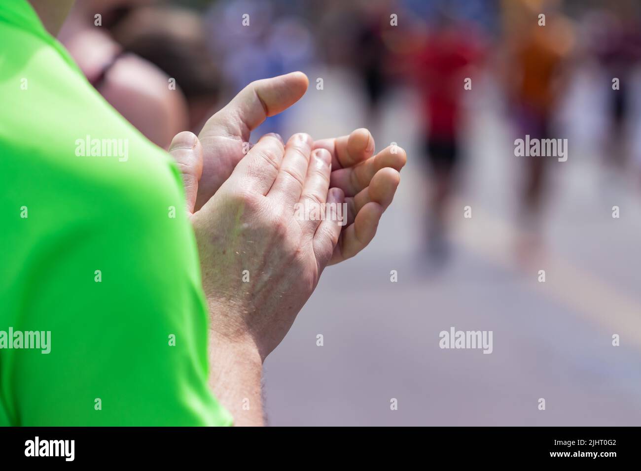 Clapping hands of an unrecognizable man at an athletics marathon ...