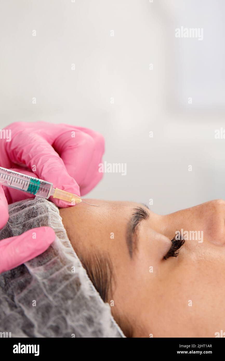 Portrait of young Caucasian woman getting botox cosmetic injection in ...