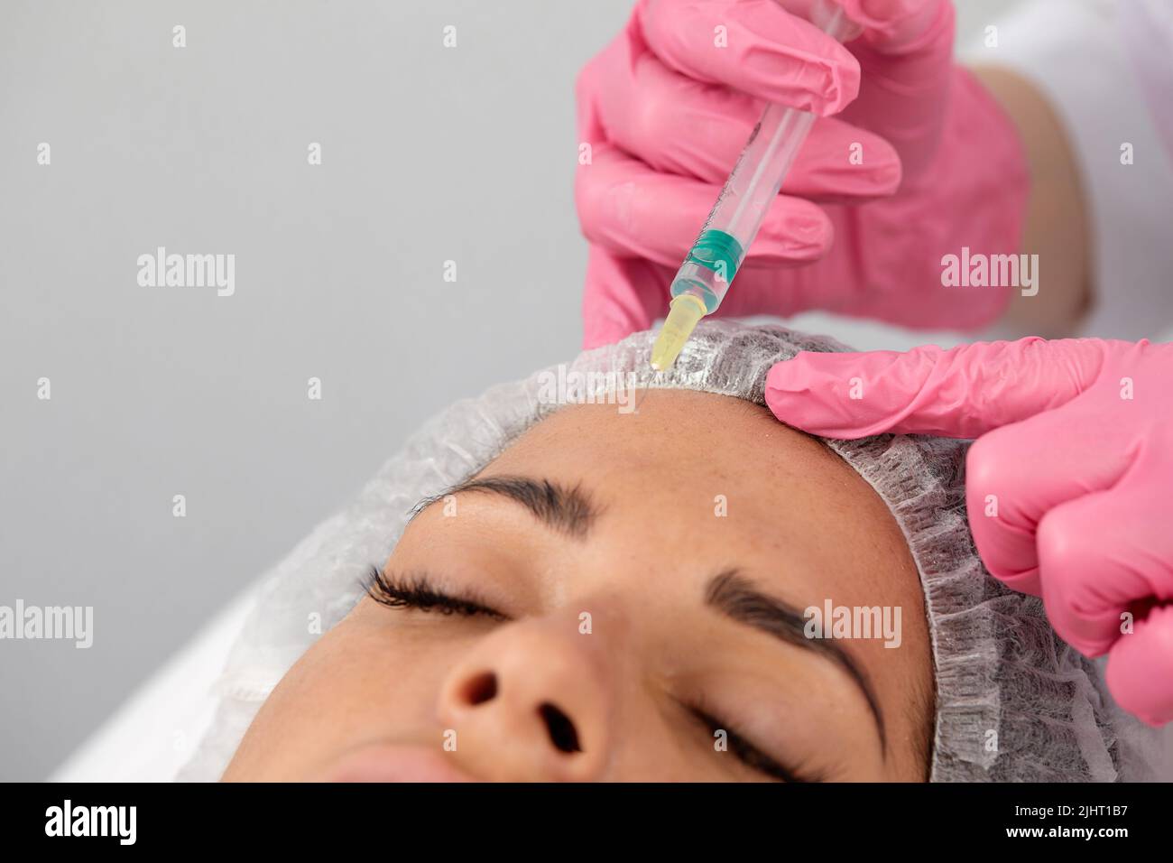 Portrait of young Caucasian woman getting botox cosmetic injection in ...